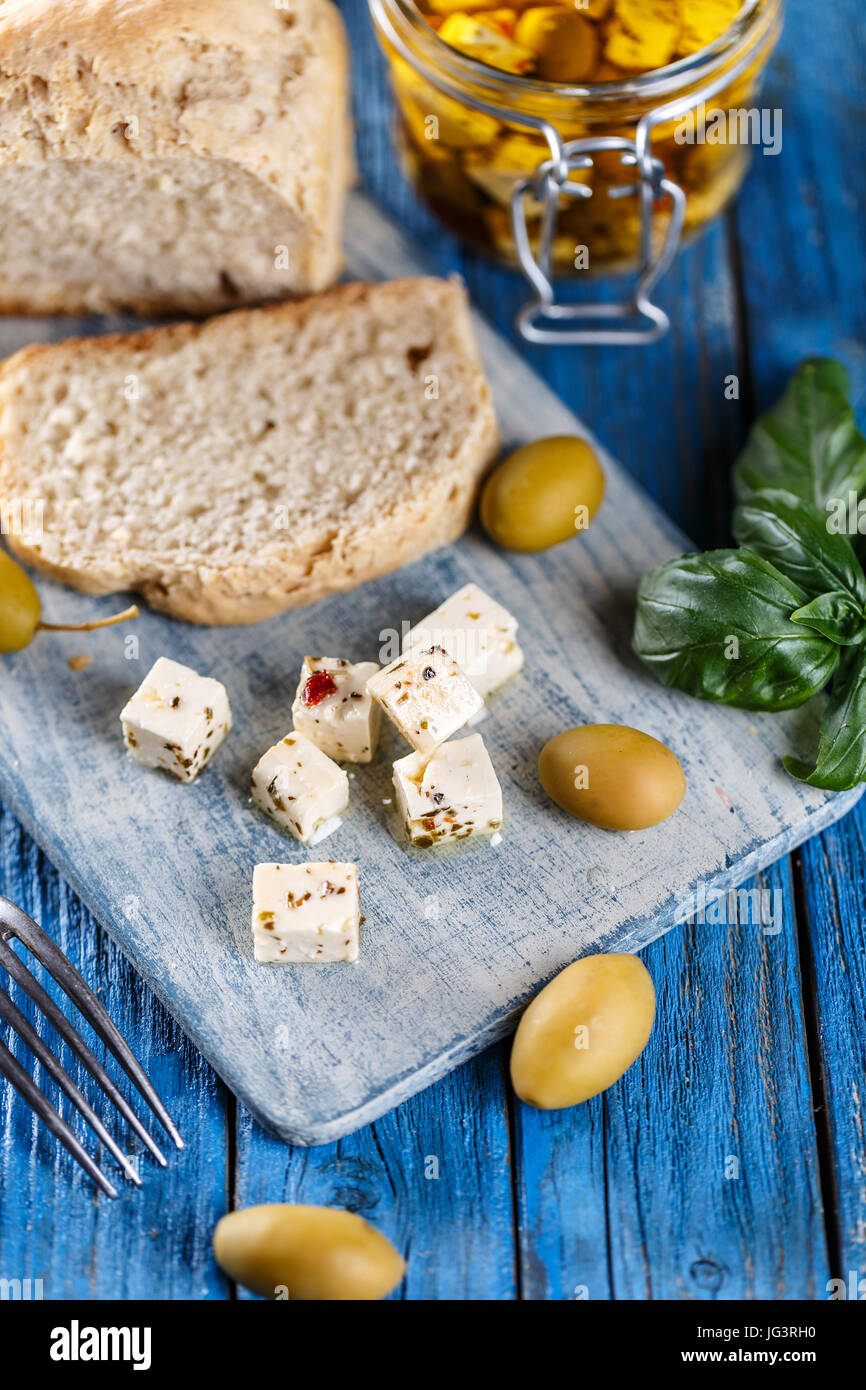 Cubes of cheese, seasoned with herbs on blue wooden background Stock ...