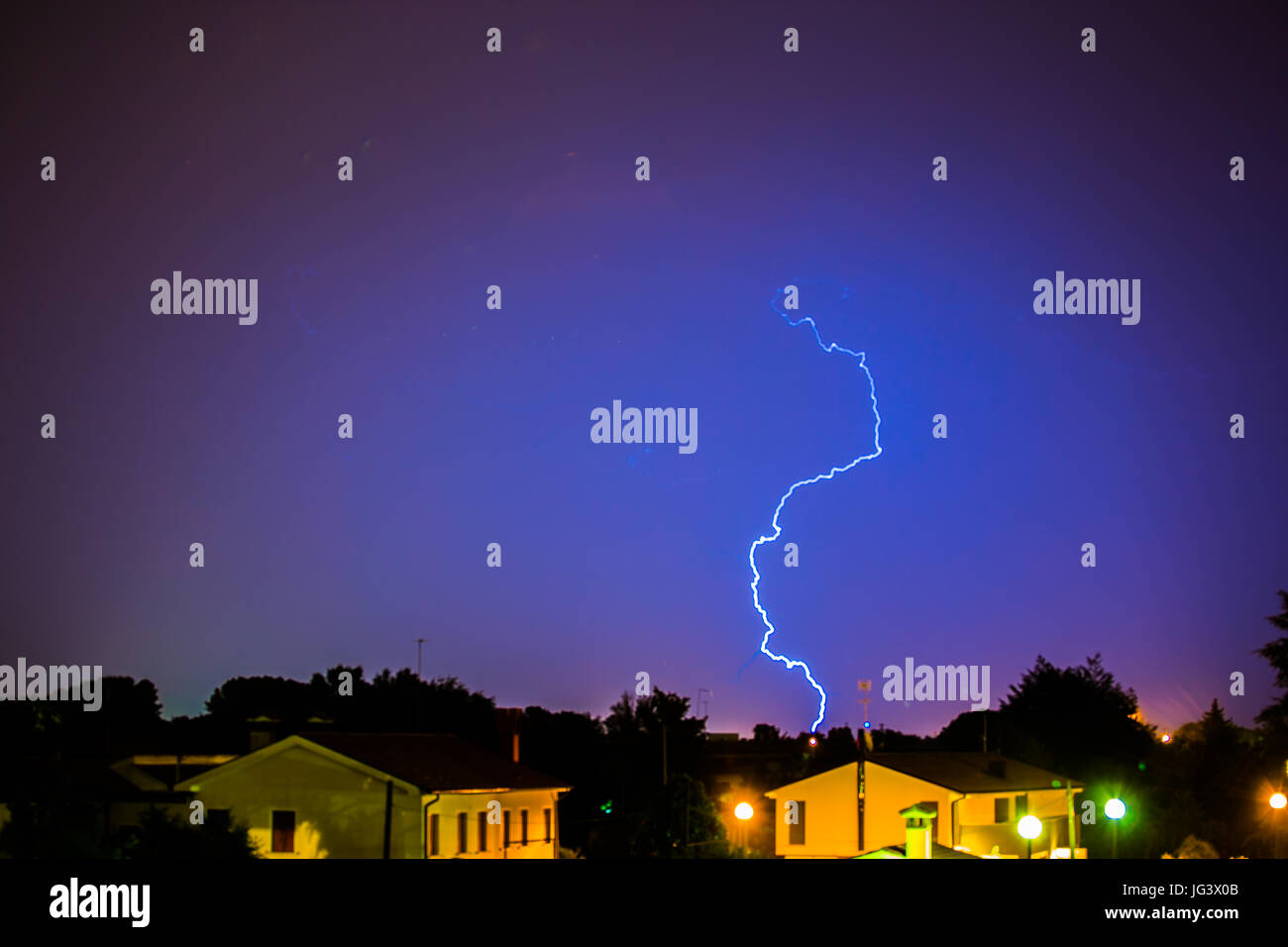 Thunderstorm. Effective lightning storm striking above houses Stock ...