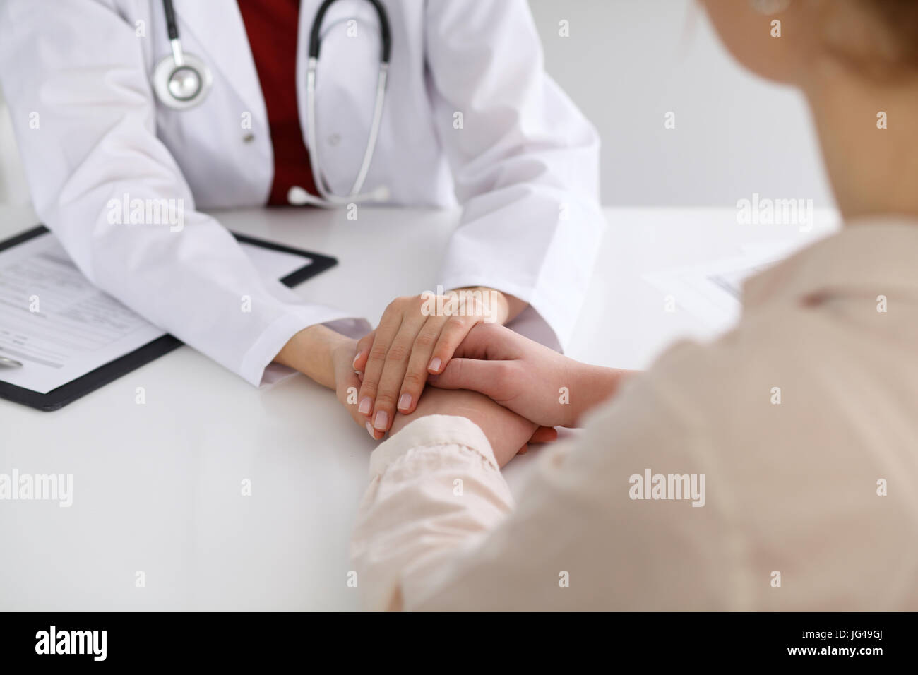 Hand of doctor reassuring her female patient Stock Photo - Alamy