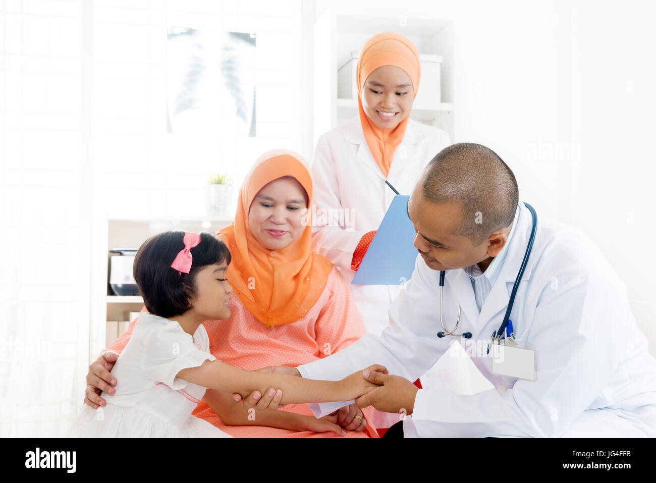 Southeast Asian child patient consulting medical doctor. Muslim family ...