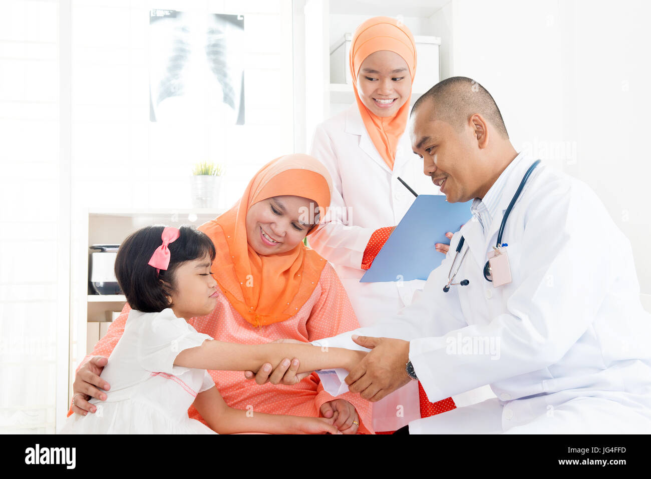 Southeast Asian kid patient consulting medical doctor. Muslim family ...