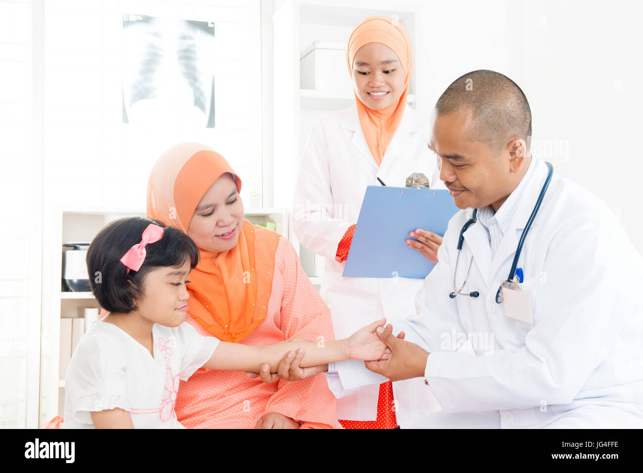 Southeast Asian kid patient consulting medical doctor. Muslim family ...