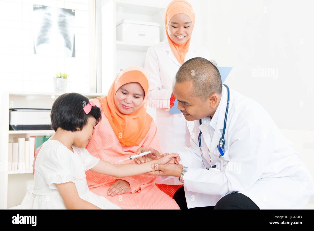 Southeast Asian doctor give injection of vaccine to children. Muslim ...