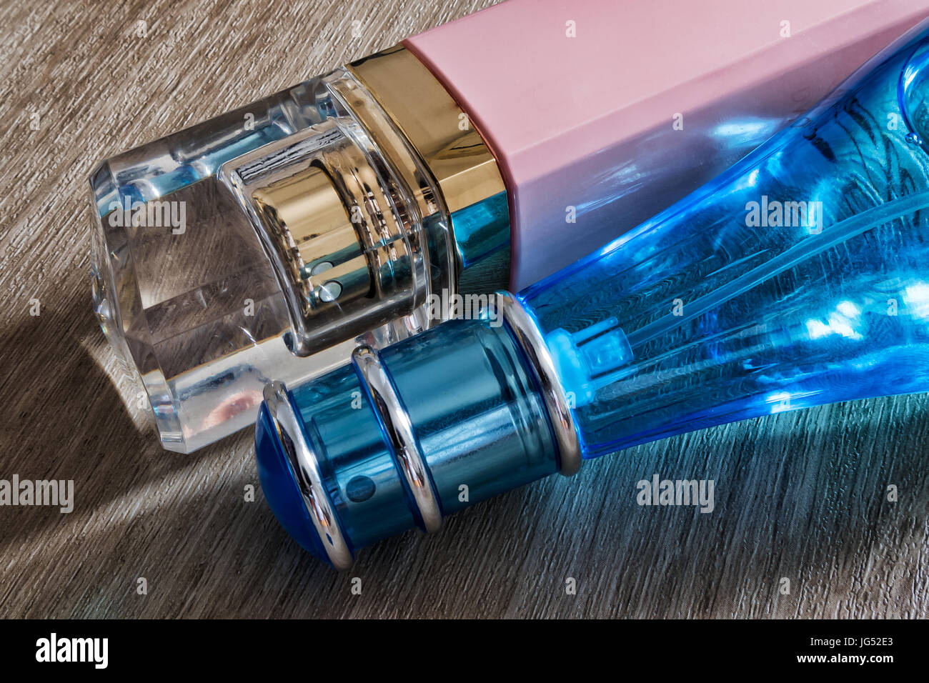 Female, pink and blue perfumes isolated on wooden background Stock ...
