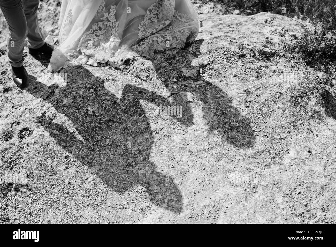 Shadow silhouettes of the wedding couple on the rock. Black and white ...