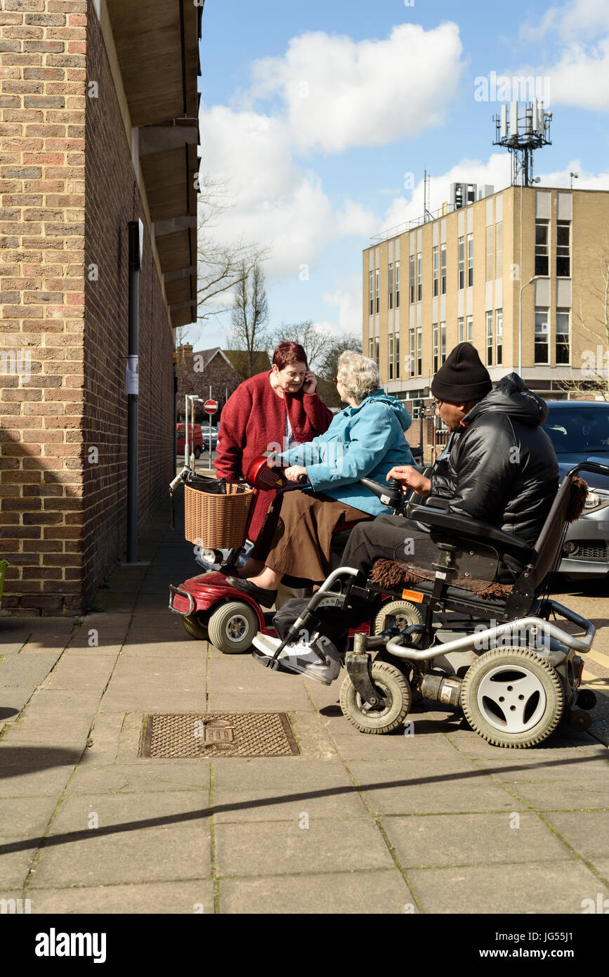 Elderly woman and a black man on mobility scooters in England Stock ...