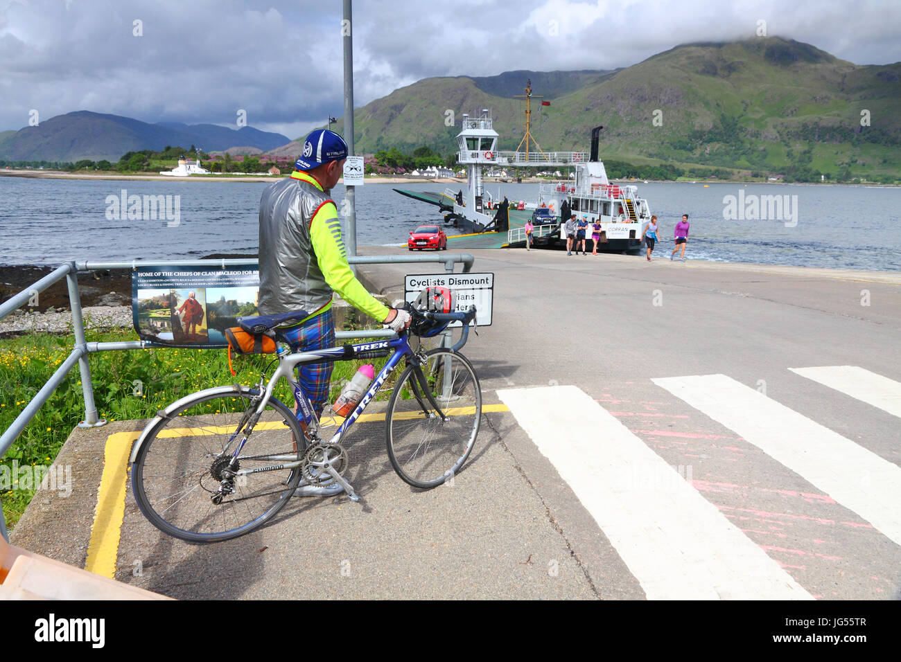 A cyclist waits to board the Corran ferry, near Fort William, Lochaber ...