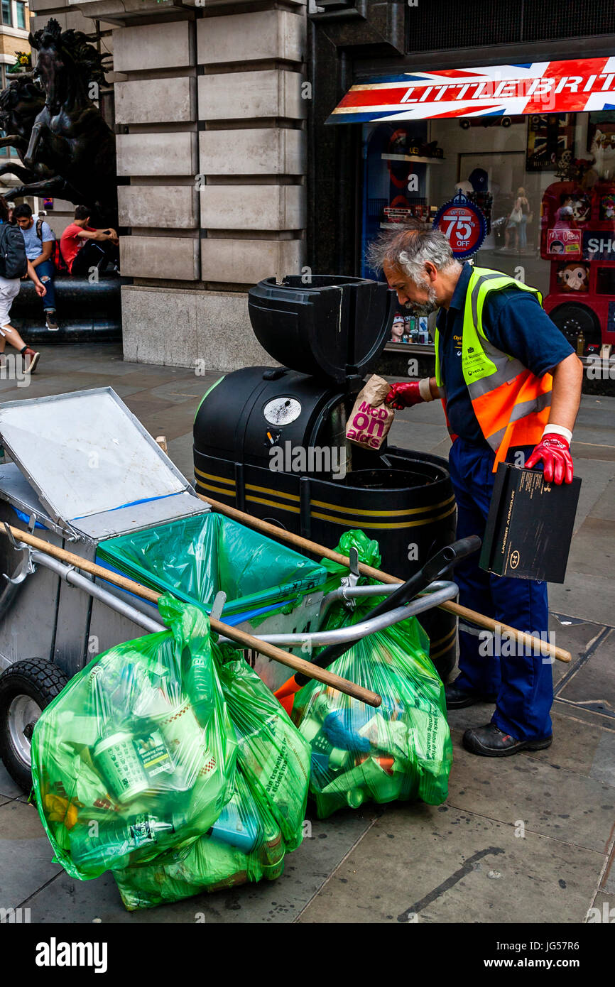 A Council Worker Collects Rubbish From A Bin, Piccadilly Circus, London ...