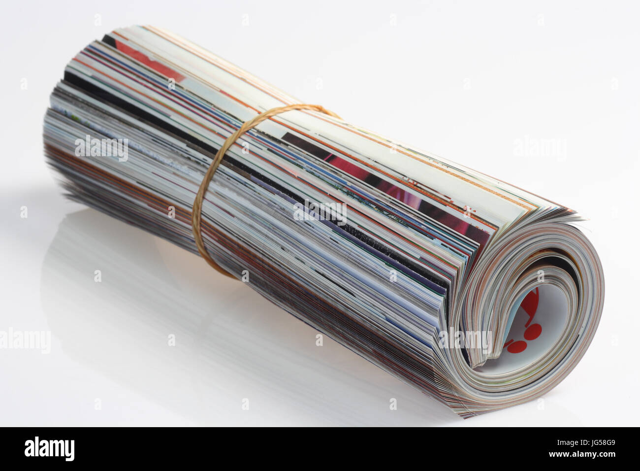 Rolled up magazine on bright background Stock Photo - Alamy