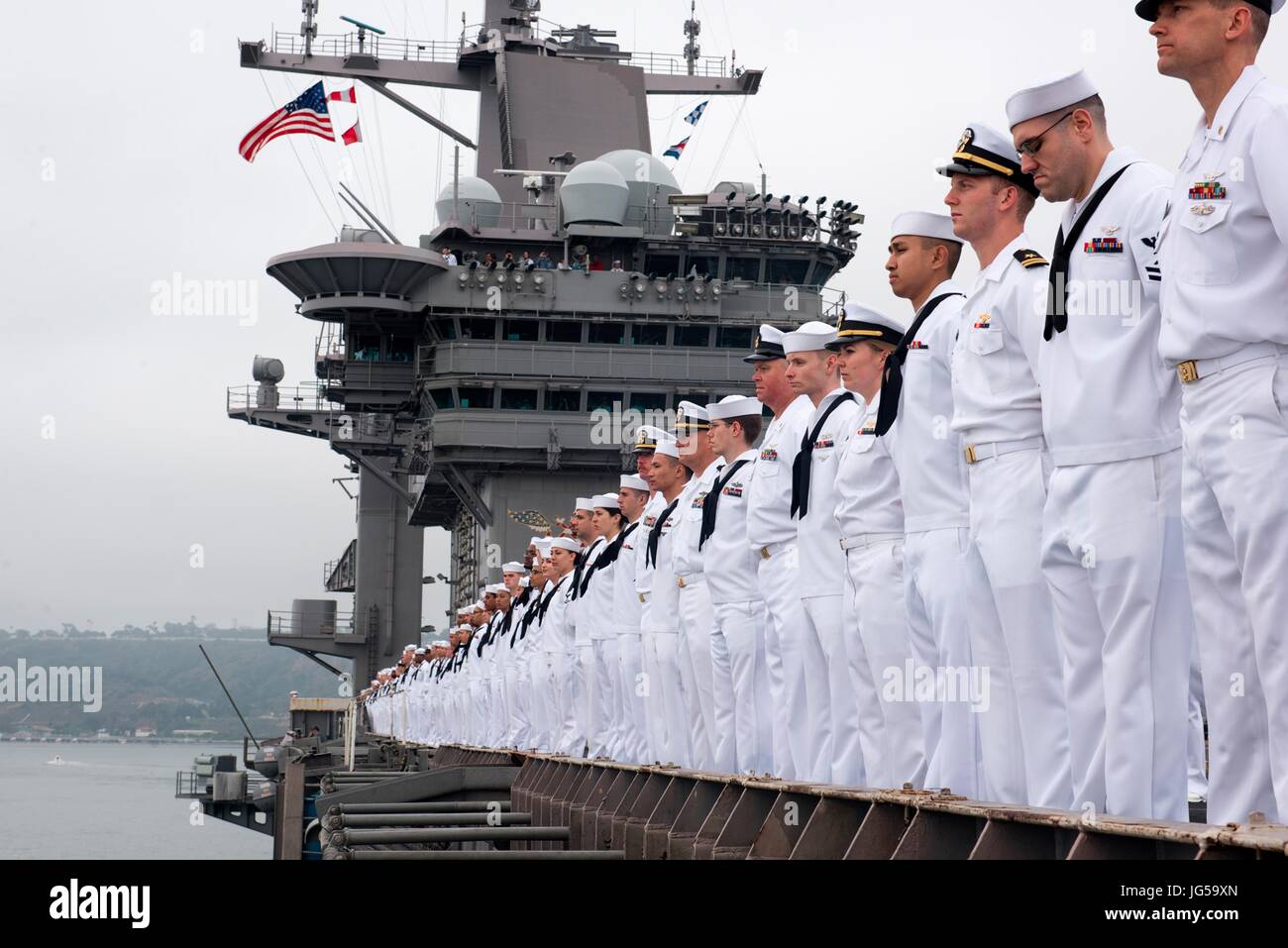 U.S. sailors main the rails of the U.S. Navy Nimitz-class aircraft ...