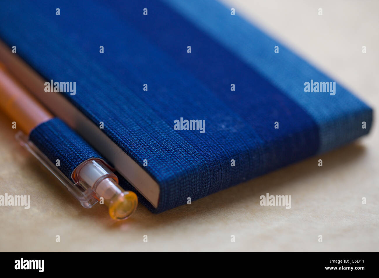 Orange Pen Blue Notepad At Table Stock Photo - Alamy