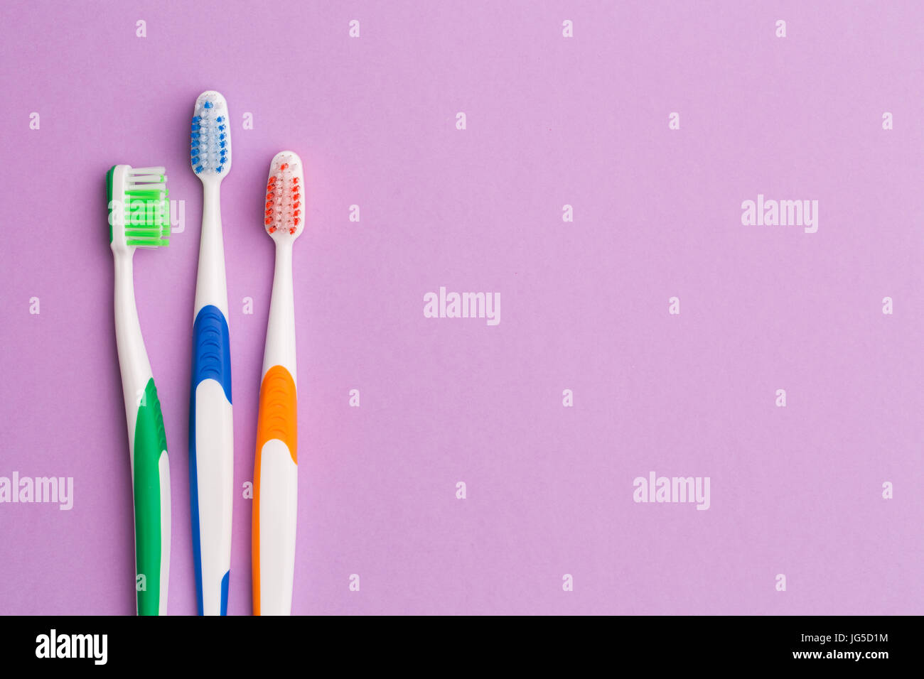 Photo of three multi-colored toothbrushes Stock Photo - Alamy