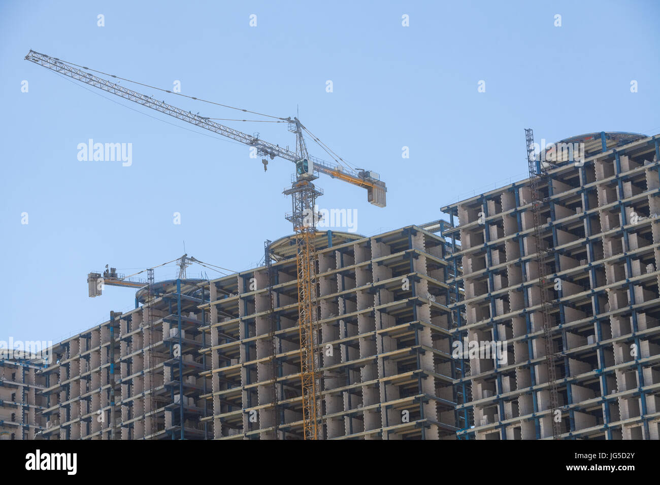 Color image of some cranes building a new structure Stock Photo - Alamy