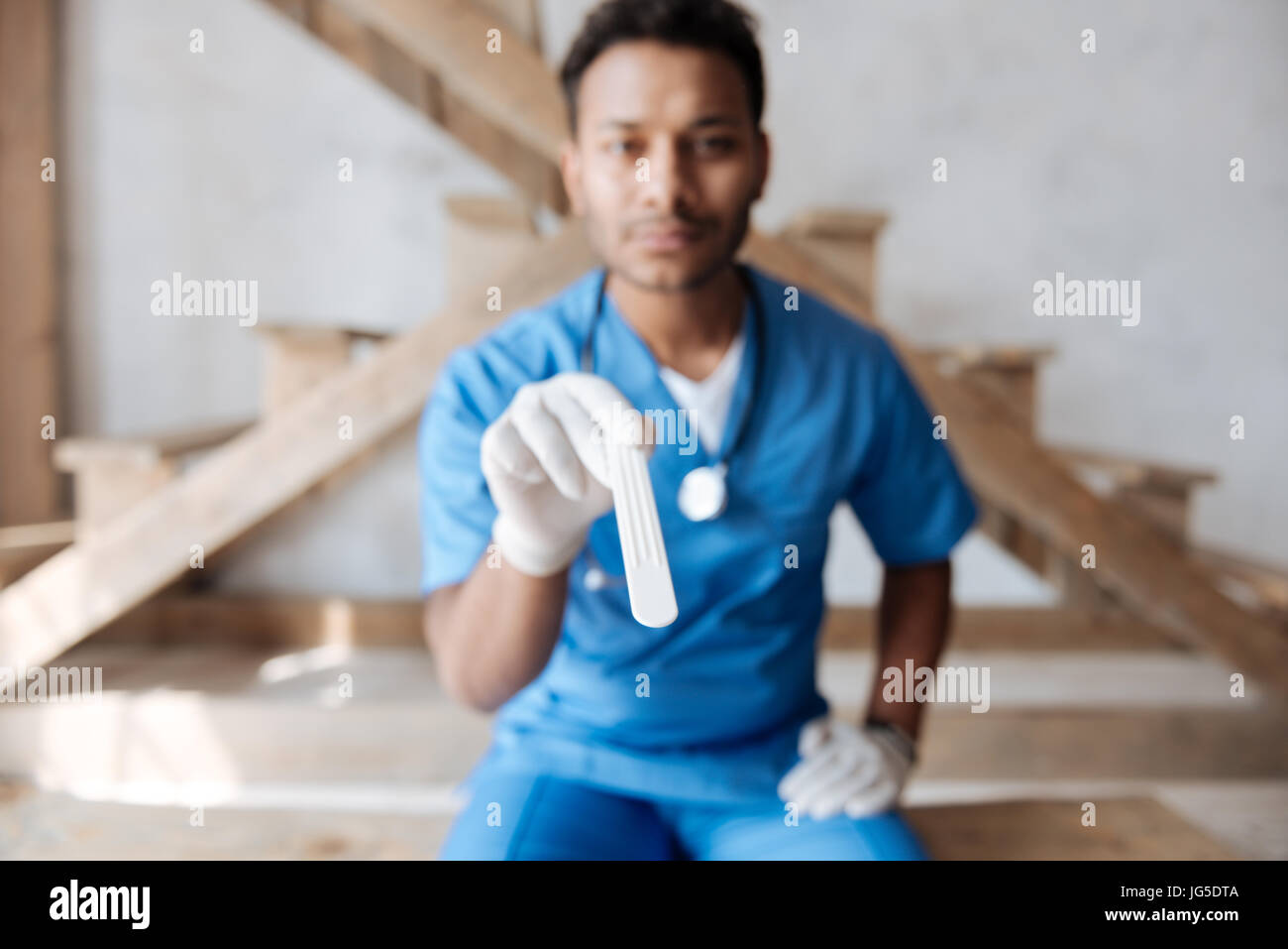 Horizontal photo of serious doctor that holding special instrument ...