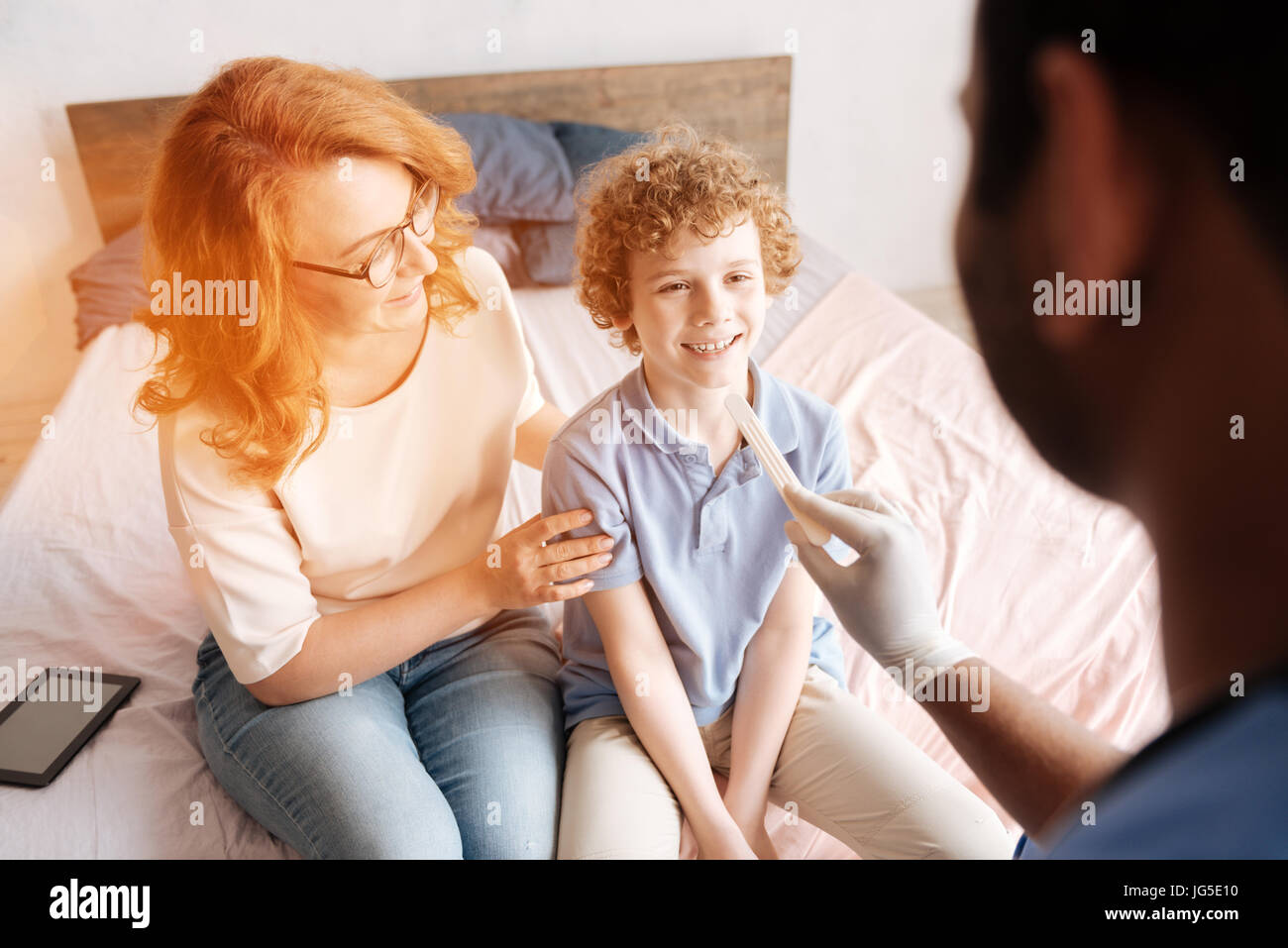 Delighted boy expressing positivity while looking at his doctor Stock ...