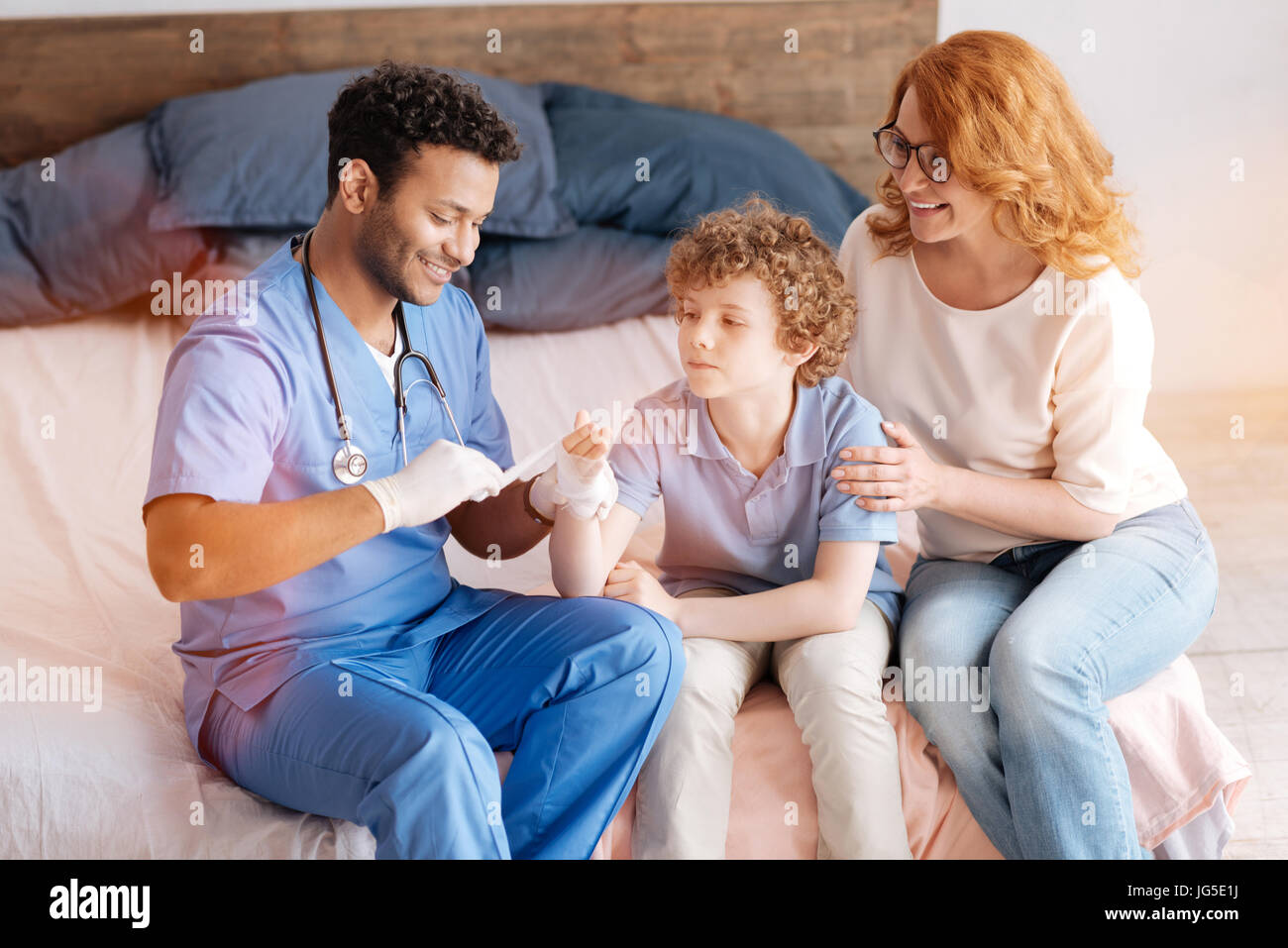 Positive delighted doctor treating his patient Stock Photo - Alamy