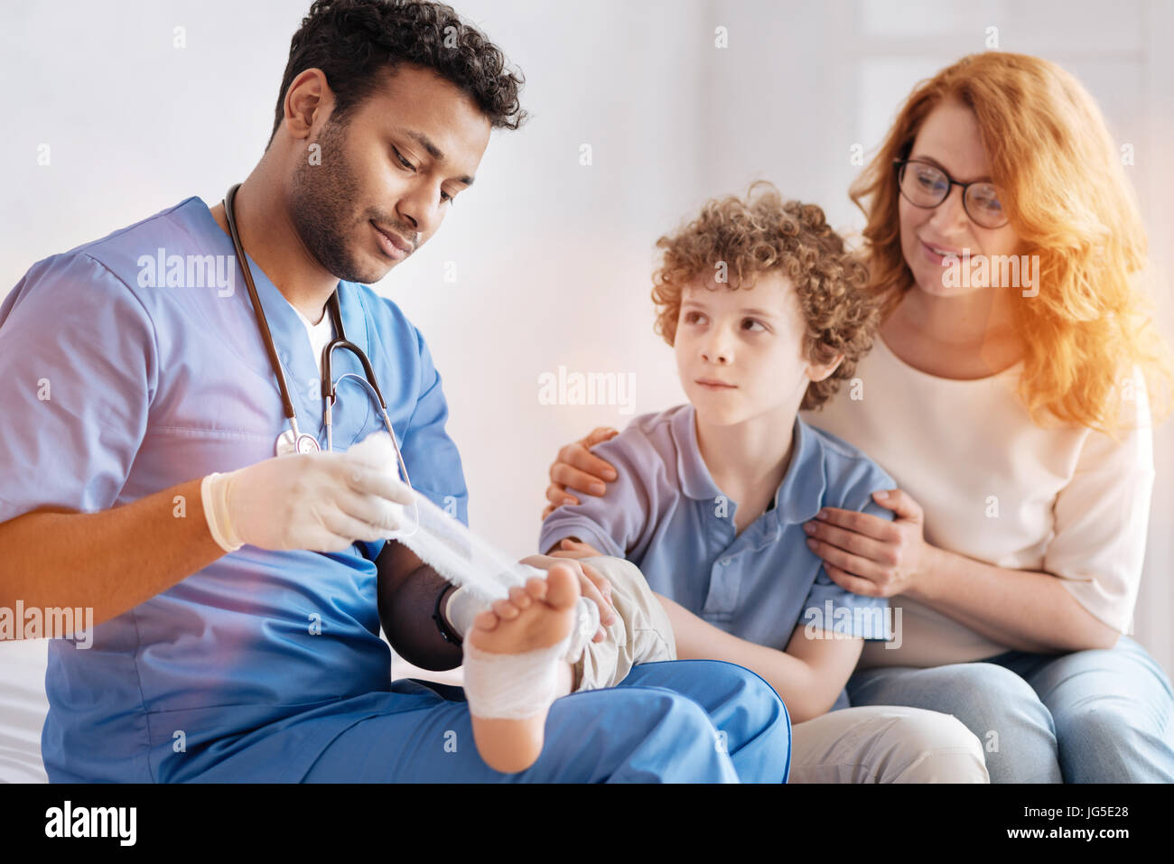 Scared boy pressing lips while looking at doctor Stock Photo - Alamy