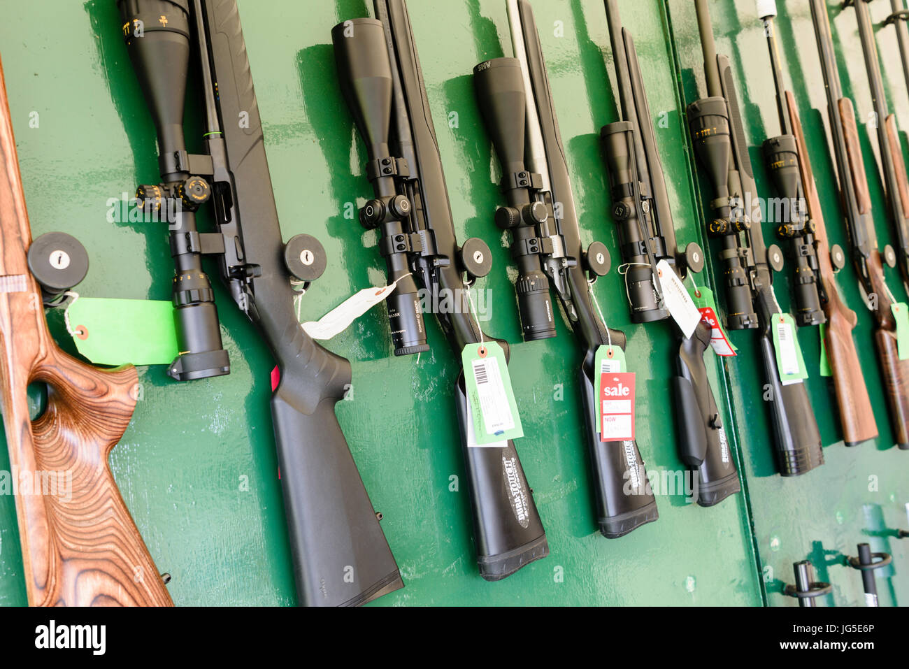 Rifles with telescopic sights for sale at a stall in a country fair ...