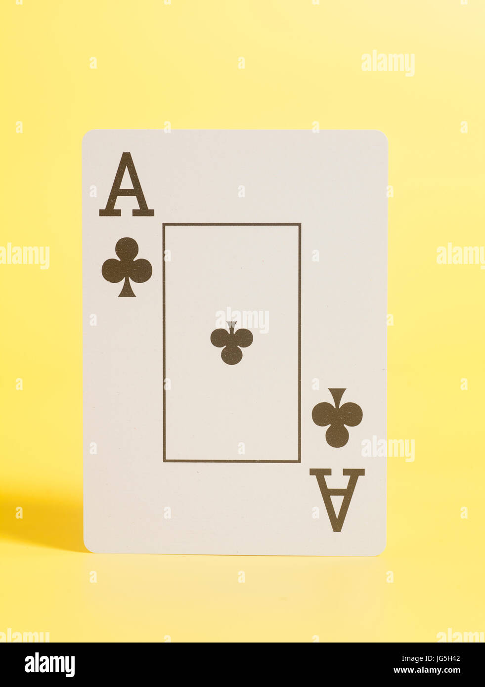 Ace of Clubs playing card on yellow background Stock Photo - Alamy