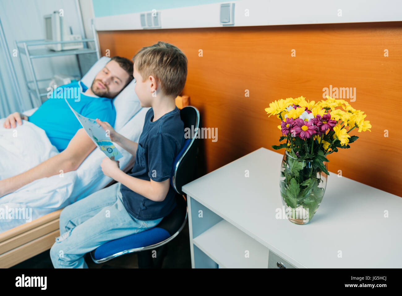 little son showing sick father his drawings at ward, hospital patient ...