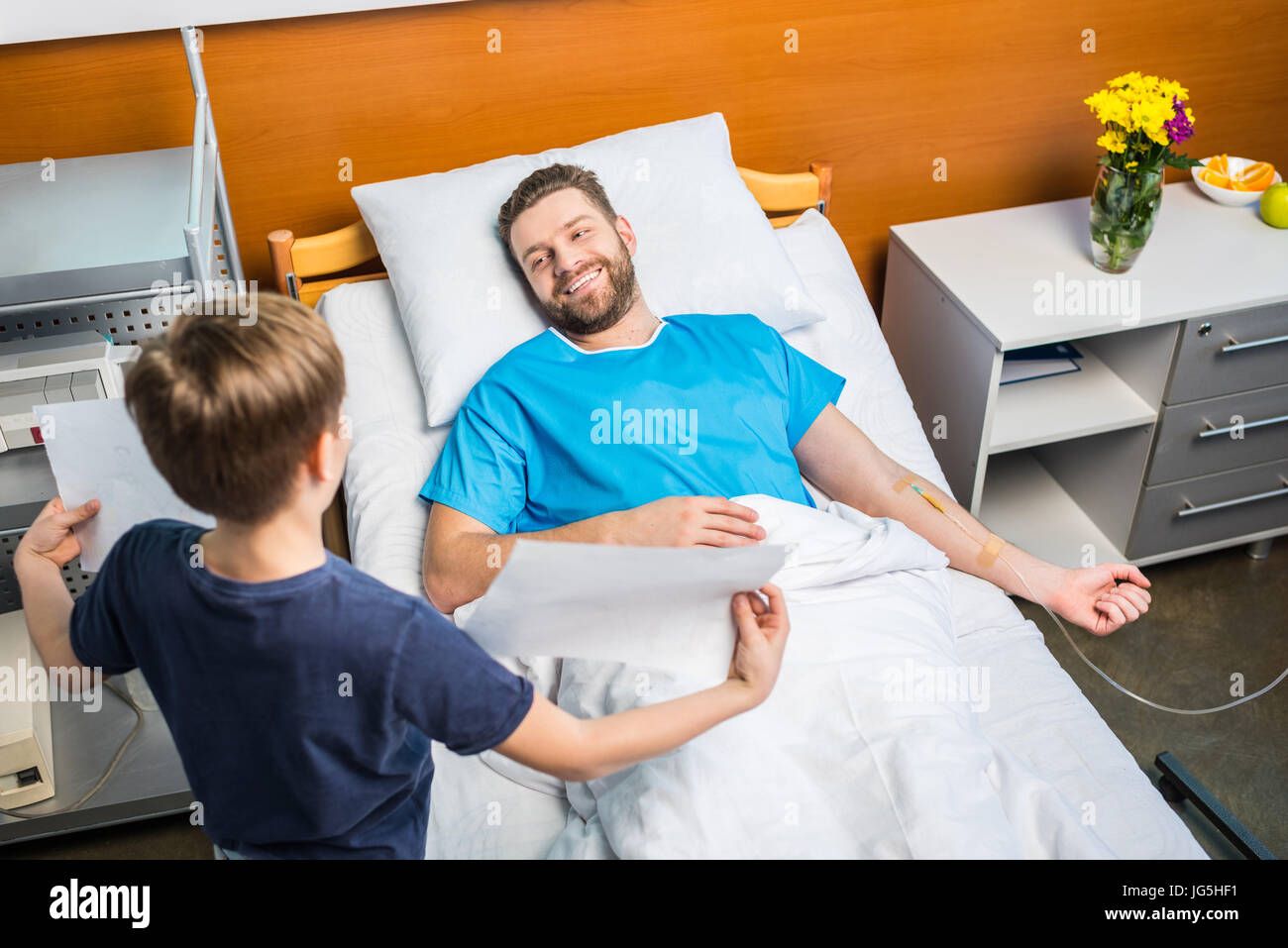 little son showing sick father his drawings at ward, dad and son Stock ...