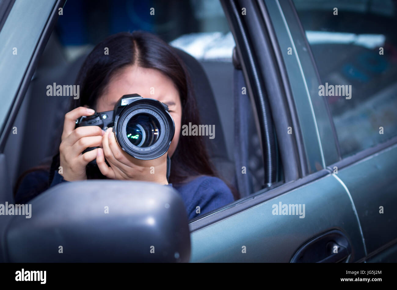 Young woman stalking and taking pictures with her camera, inside of her ...