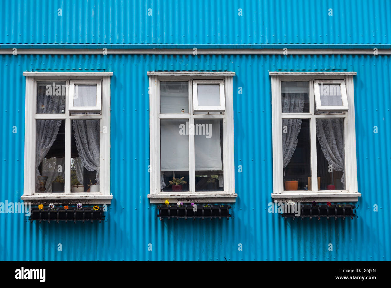 Three white windows on the side of a blue house in Reykjavik Stock ...