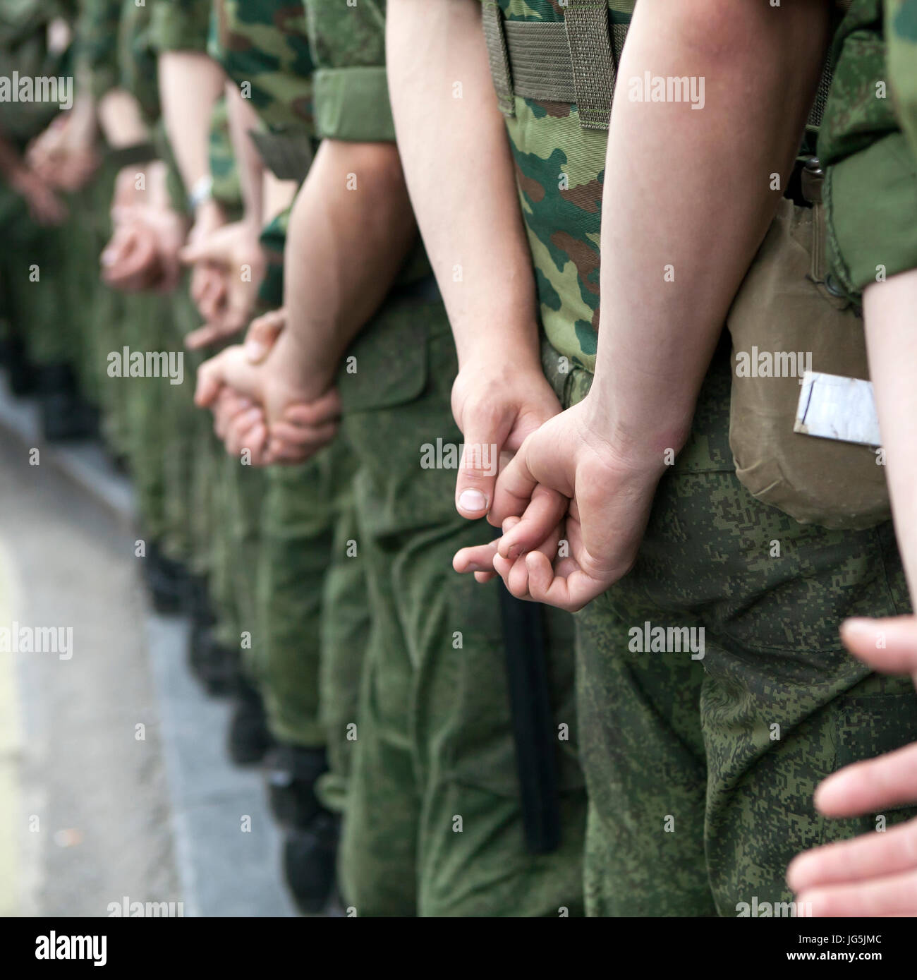 Back view. Soldiers in camouflage uniforms stand on the manifestation ...