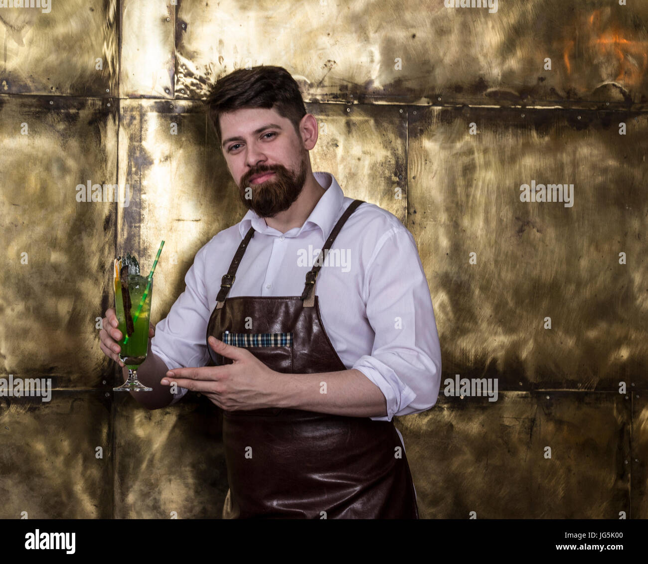 Portrait of cheerful bartender standing and smiling in bar and holding ...