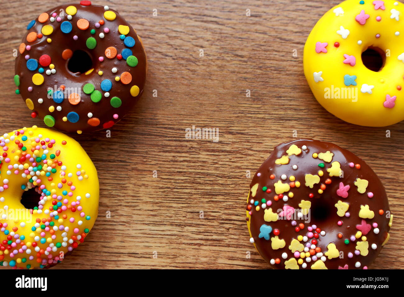 Four donuts composition on a wood background Stock Photo - Alamy