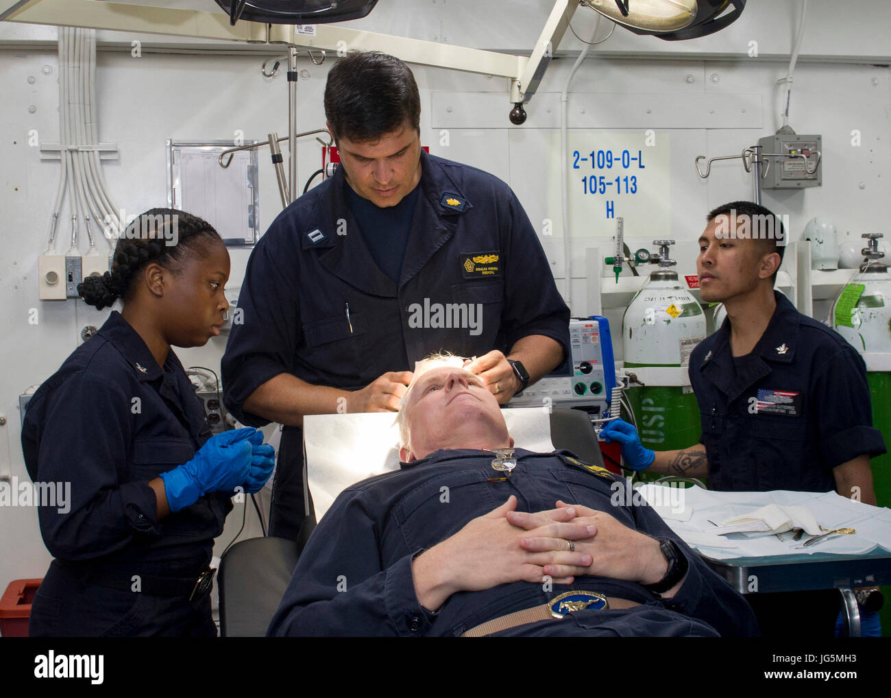 Hospital Corpsmen perform a cyst removal surgery aboard the aircraft ...