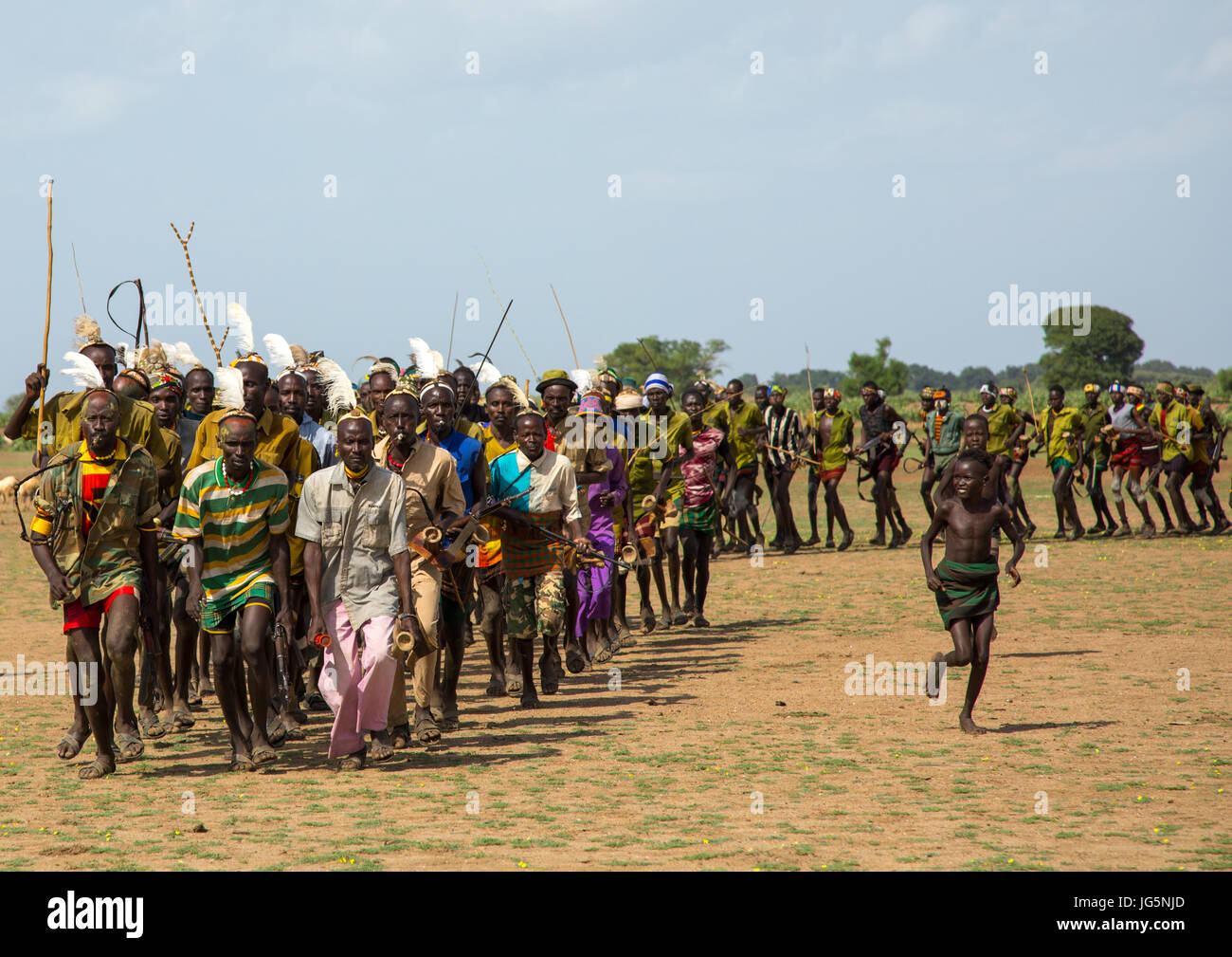 Men running in line with weapons during the proud ox ceremony in the ...