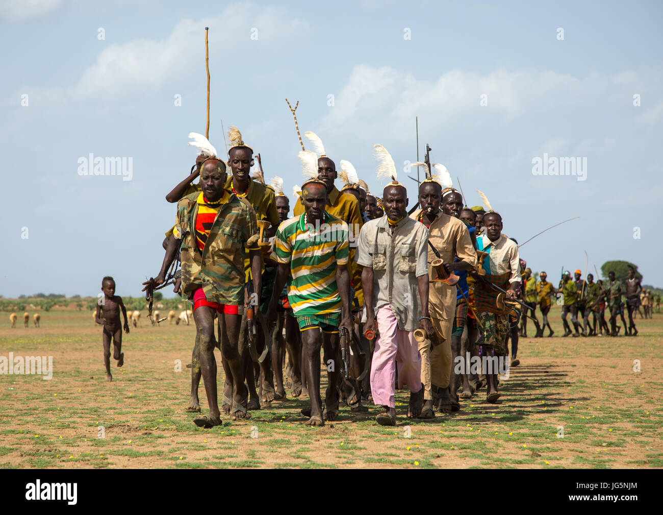 Men running in line with weapons during the proud ox ceremony in the ...