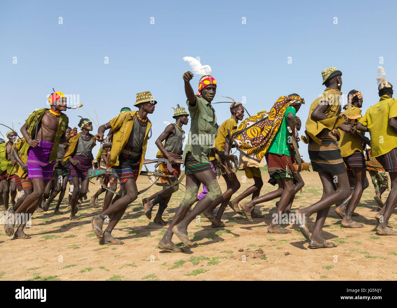 Men running in line with weapons during the proud ox ceremony in the ...