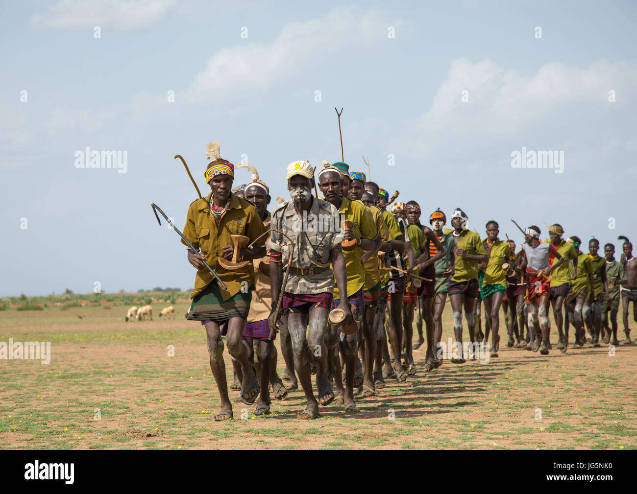 Men running in line with weapons during the proud ox ceremony in the ...