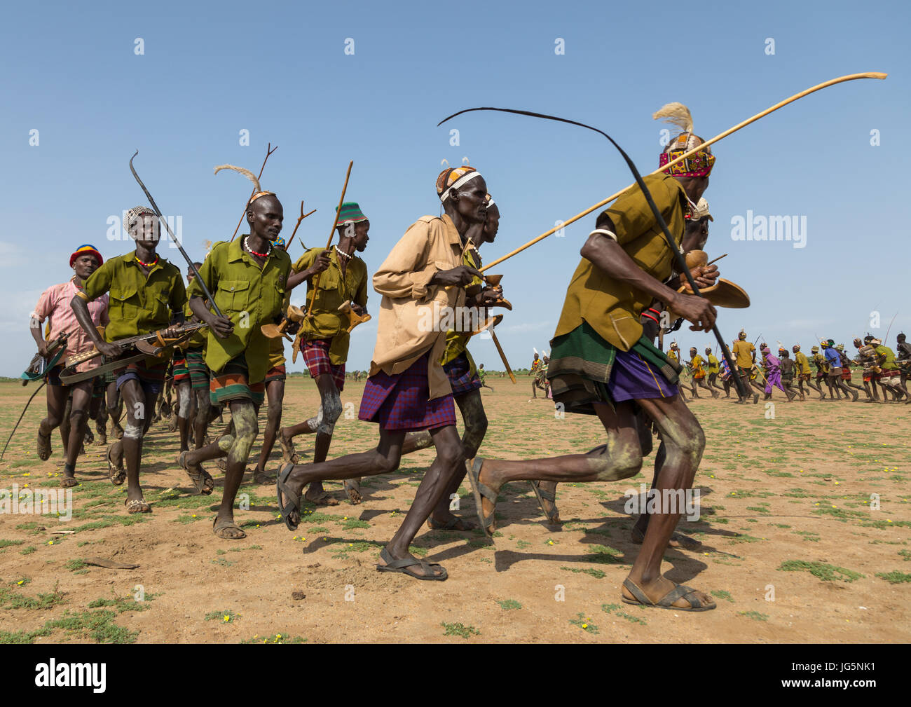 Men running in line with weapons during the proud ox ceremony in the ...