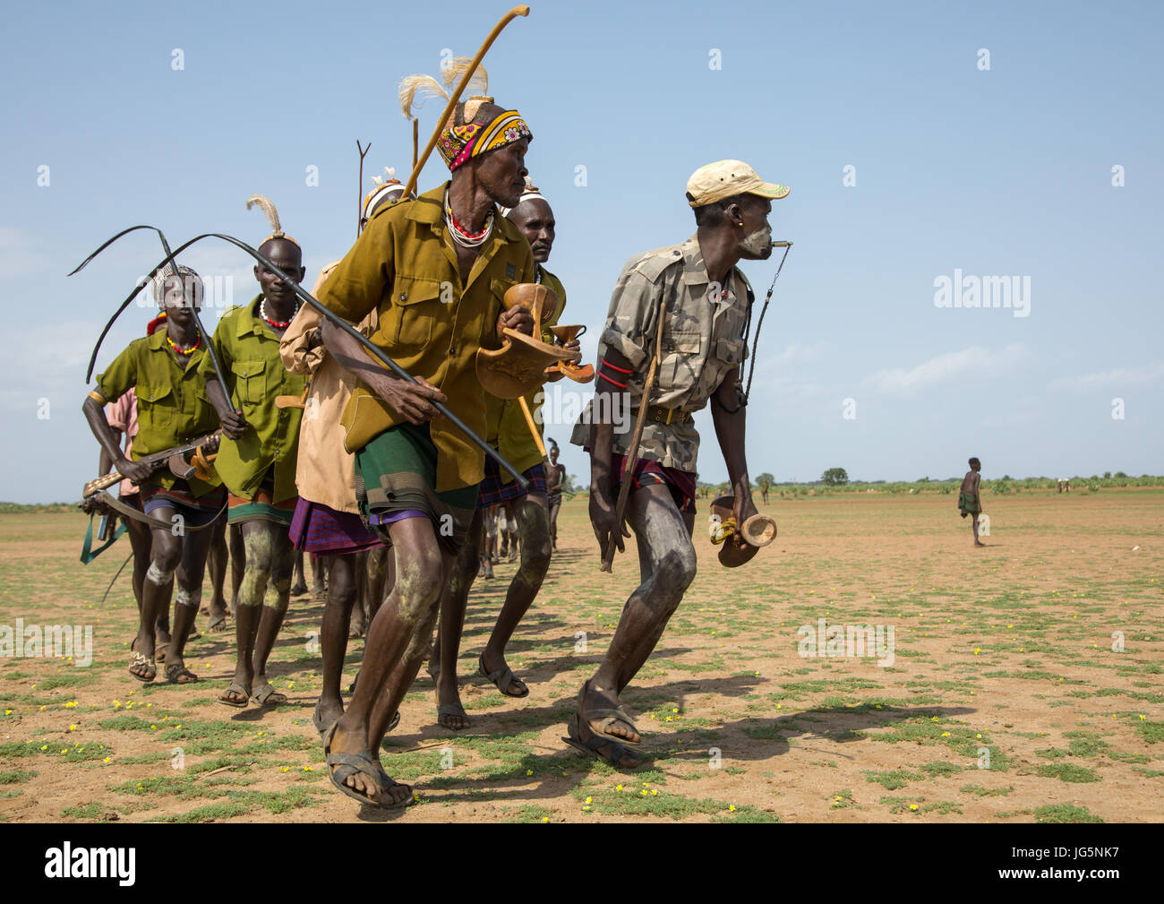 Men running in line with weapons during the proud ox ceremony in the ...