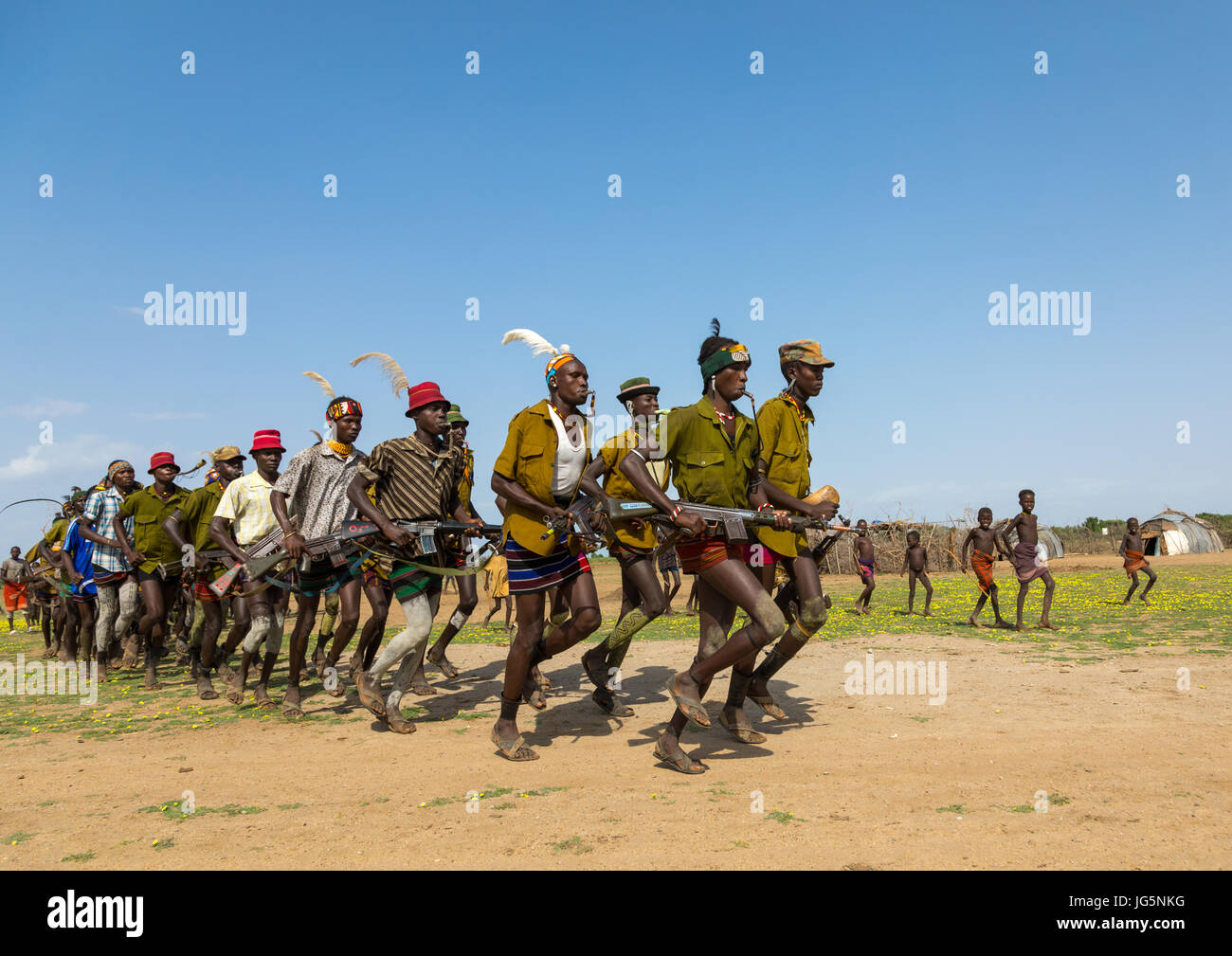Men running in line with weapons during the proud ox ceremony in the ...