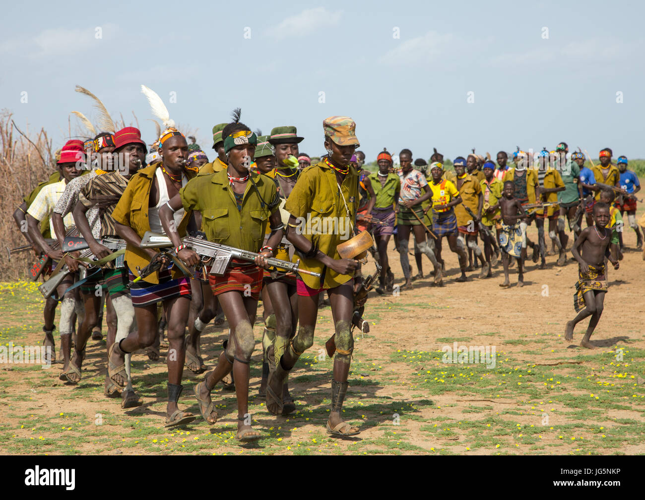 Men running in line with weapons during the proud ox ceremony in the ...