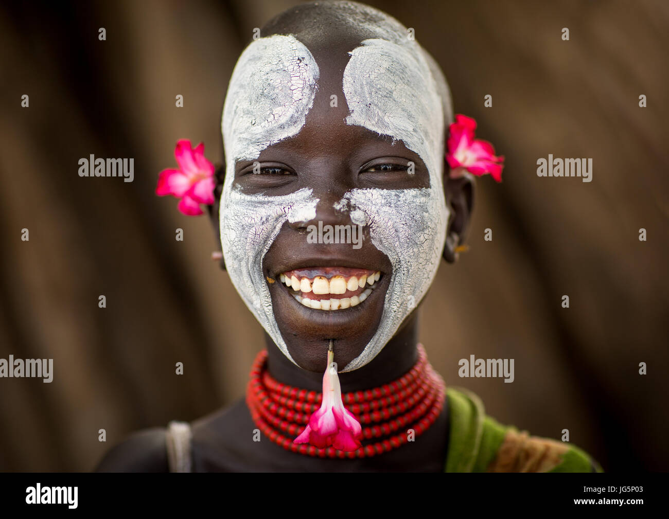 Portrait of a smiling Karo tribe child with flowers decorations, Omo ...