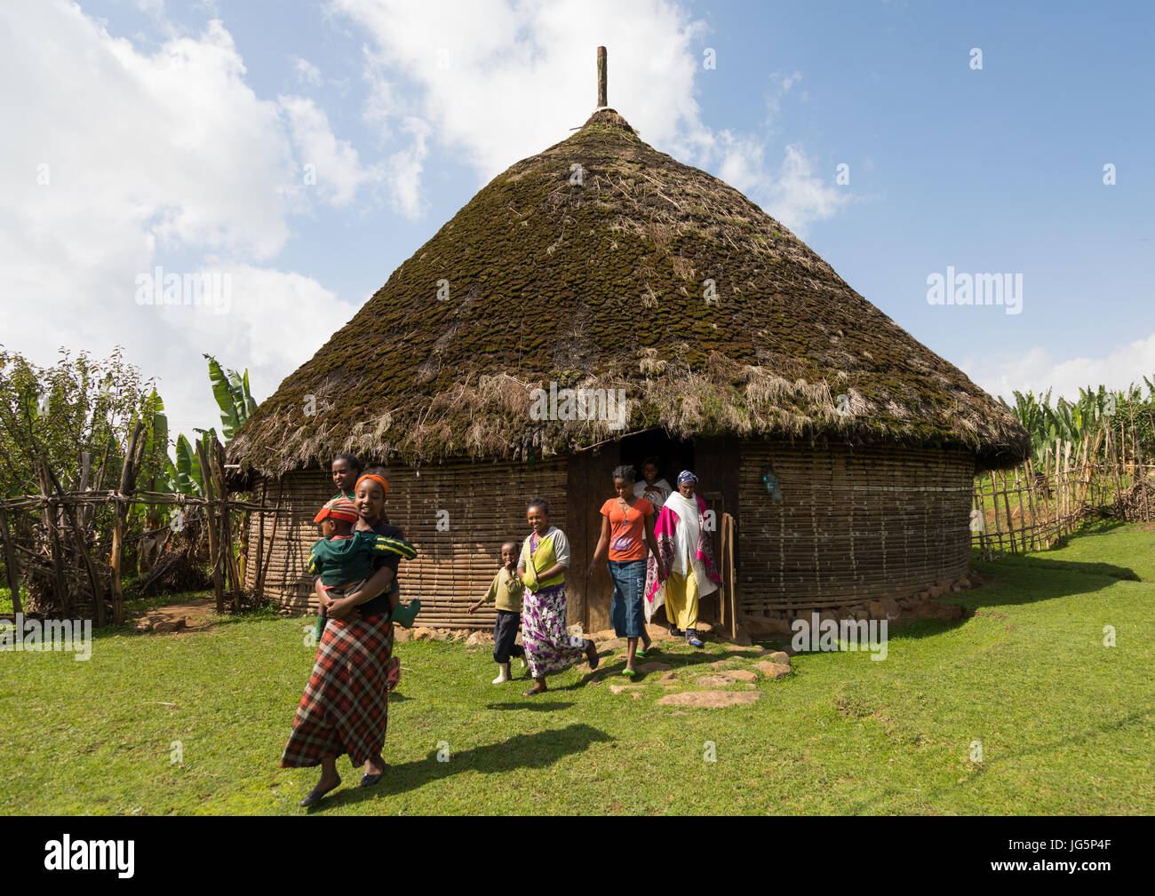 People in front of a Gurage traditional house with thatched roof ...