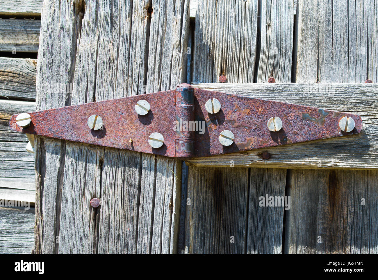 rusted double hinge on weathered wood Stock Photo - Alamy