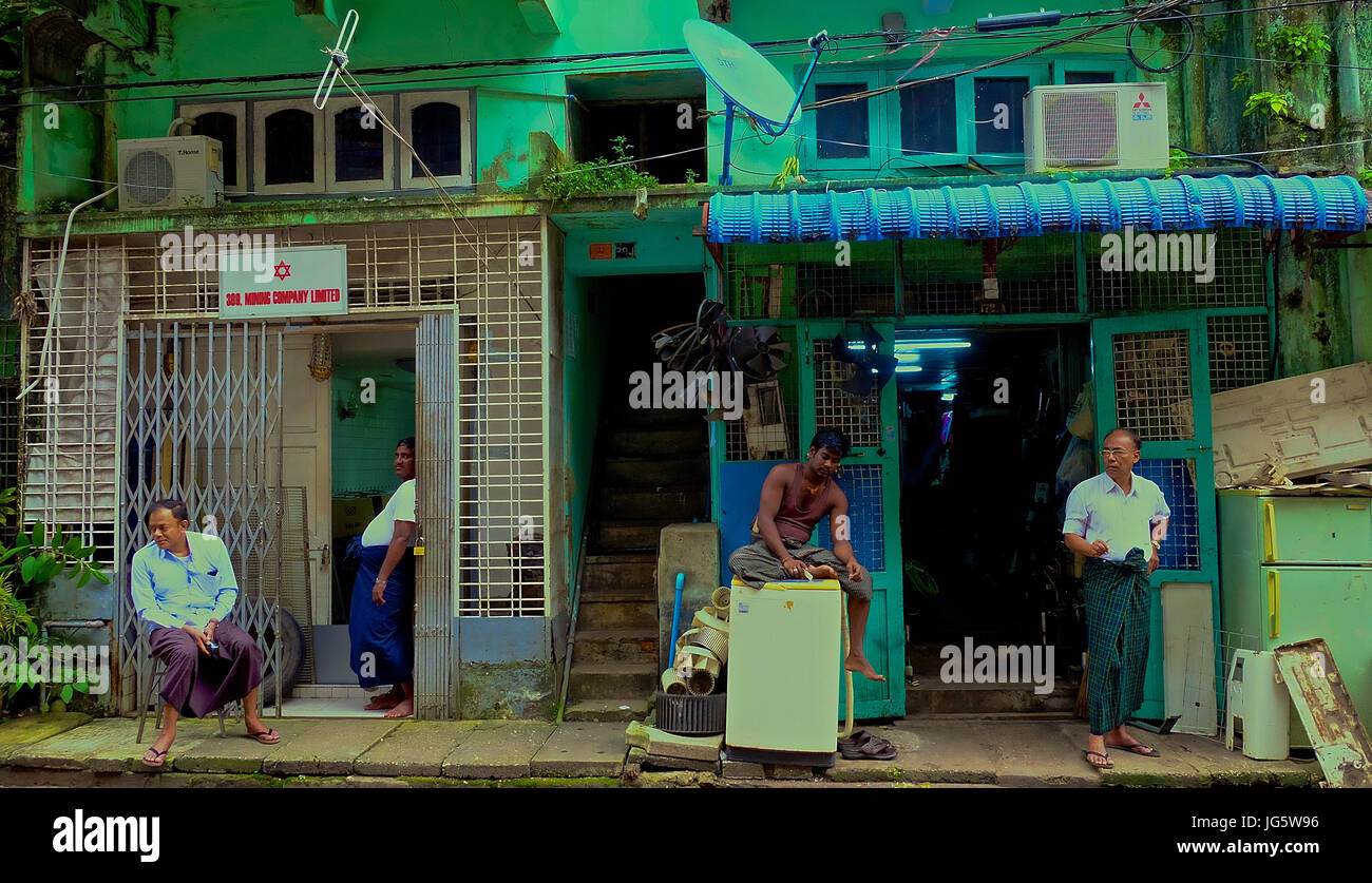 Residents sit and stand outside their homes in downtown Yangon, Myanmar ...