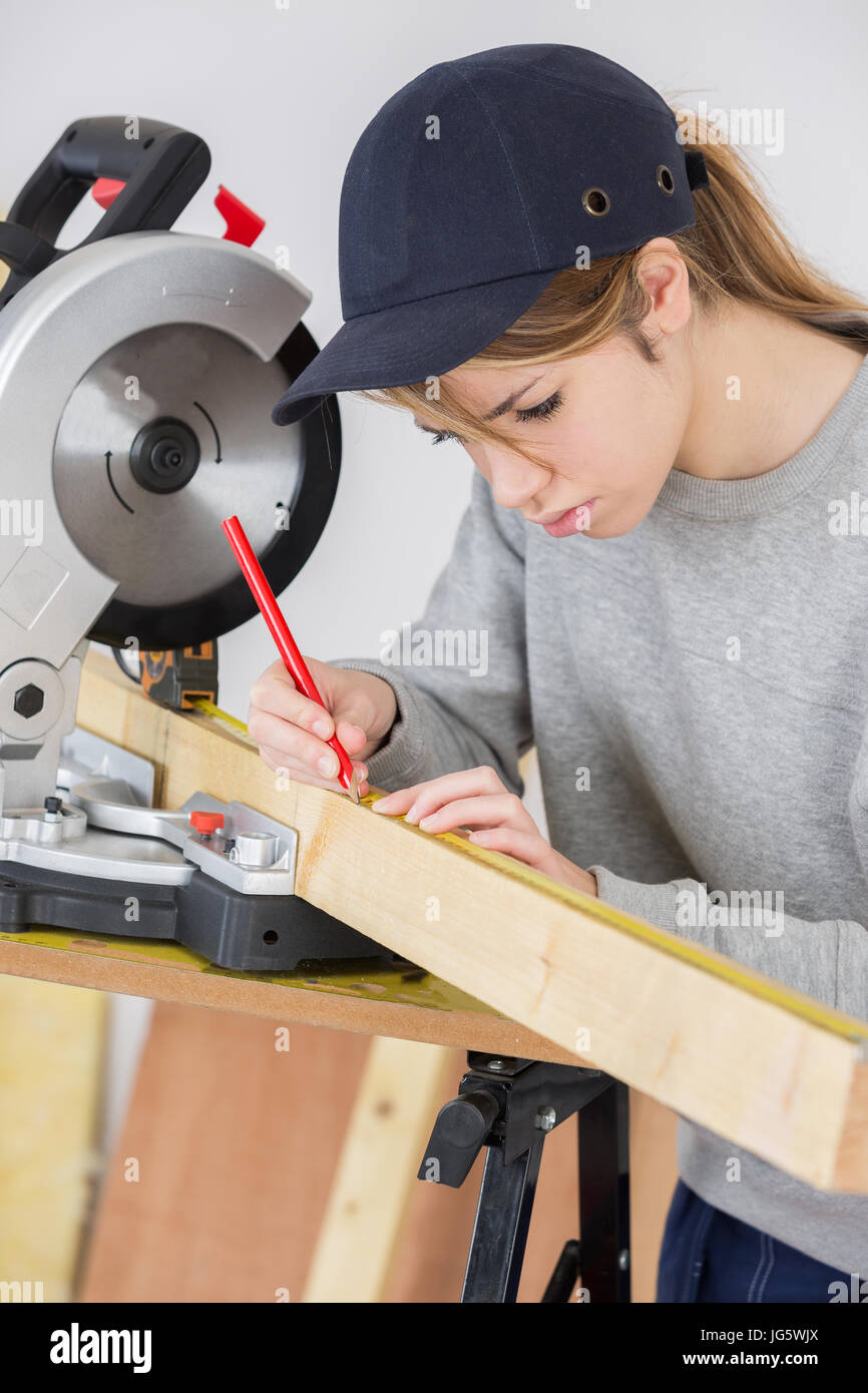 female carpenter measuring wood with scale in workshop Stock Photo - Alamy