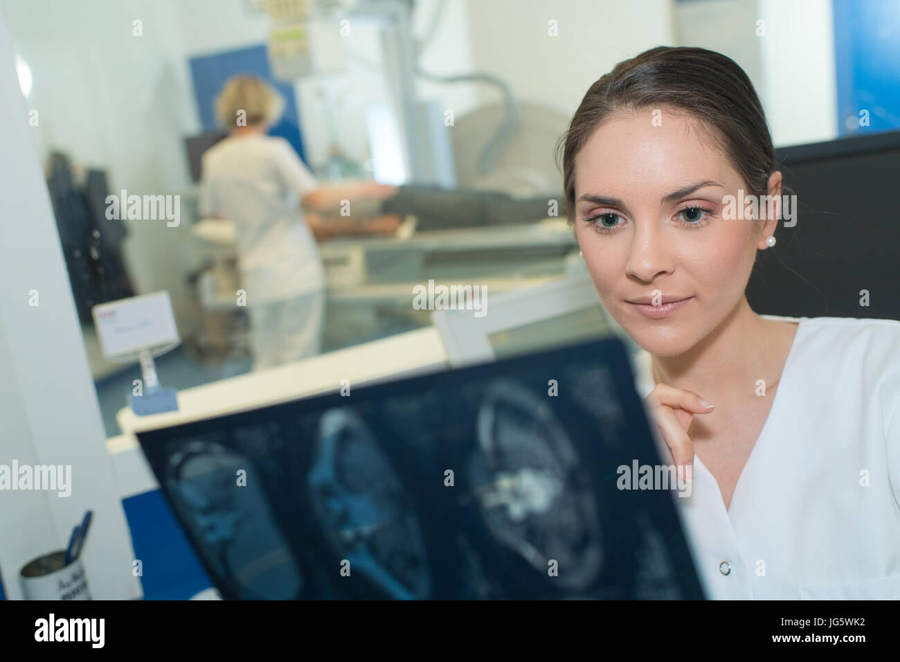 female radiologist examining brain scan by mri machine Stock Photo - Alamy