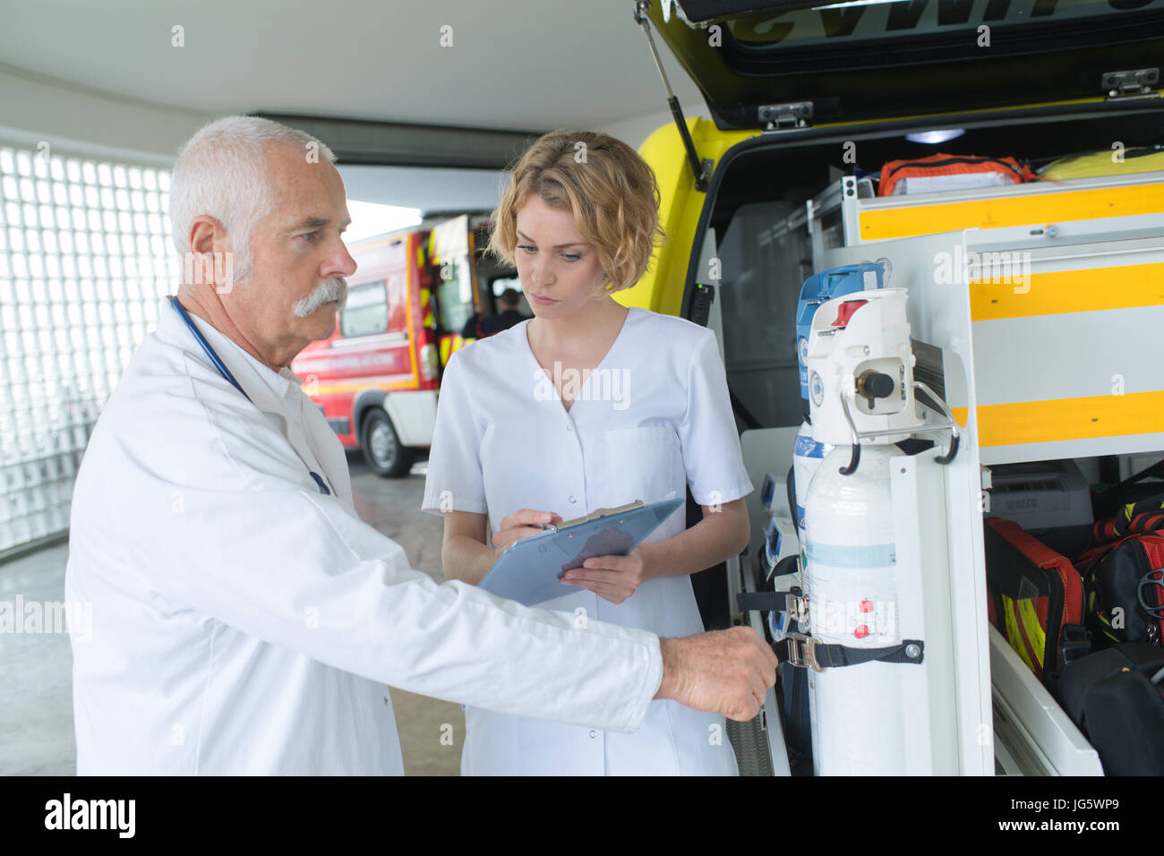 doctor and paramedic or ambulance team reviewing gear at hq Stock Photo ...
