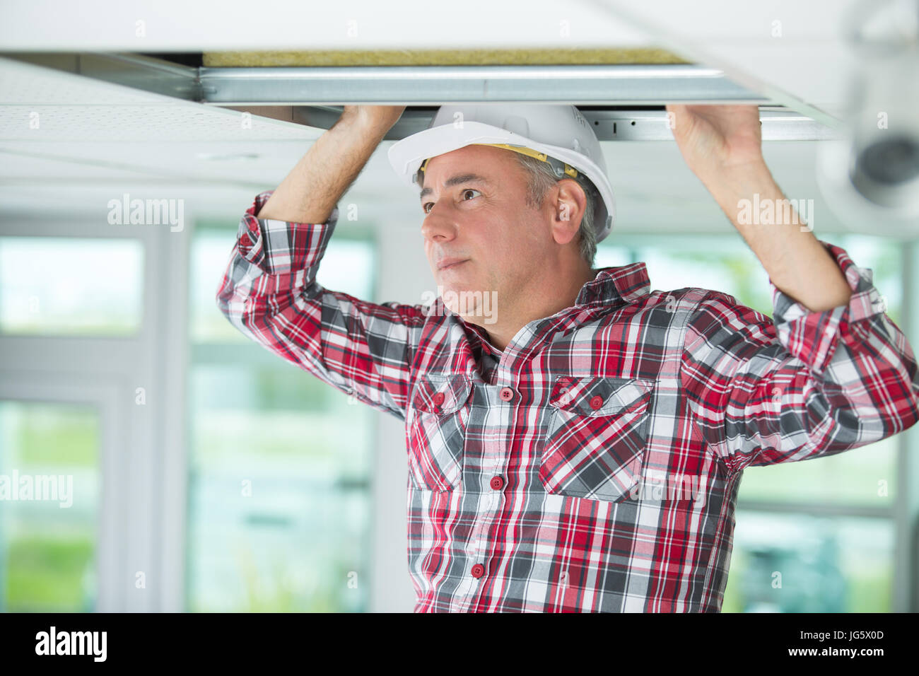builder replacing ceiling panel Stock Photo - Alamy