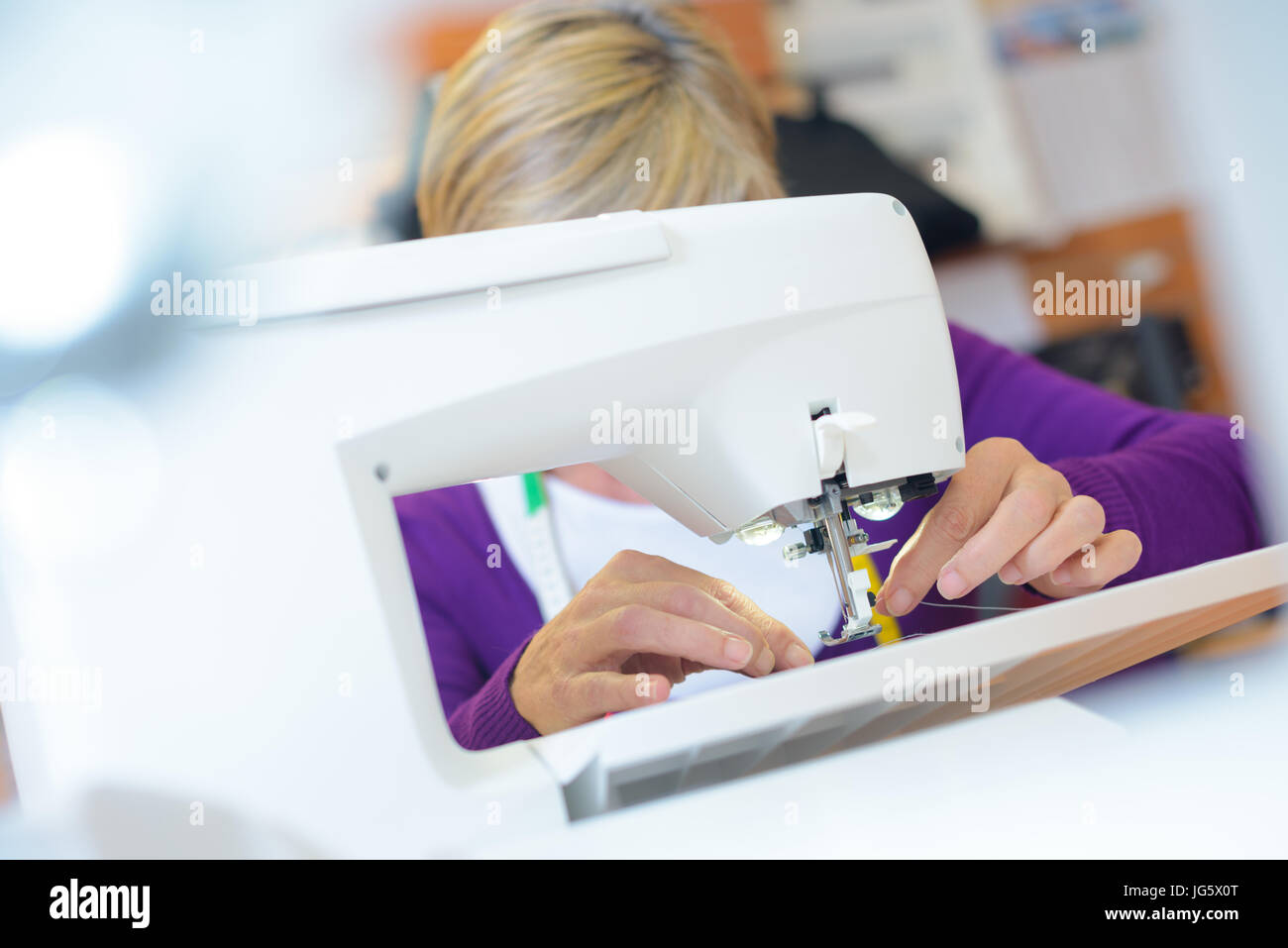woman putting a thread in a sewing machine Stock Photo - Alamy
