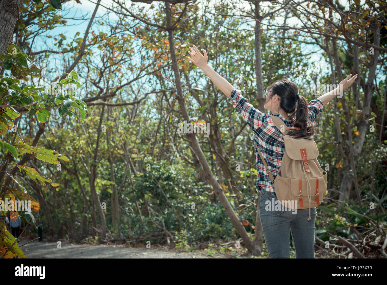 happy pretty woman traveler standing in forest path and opening arms ...