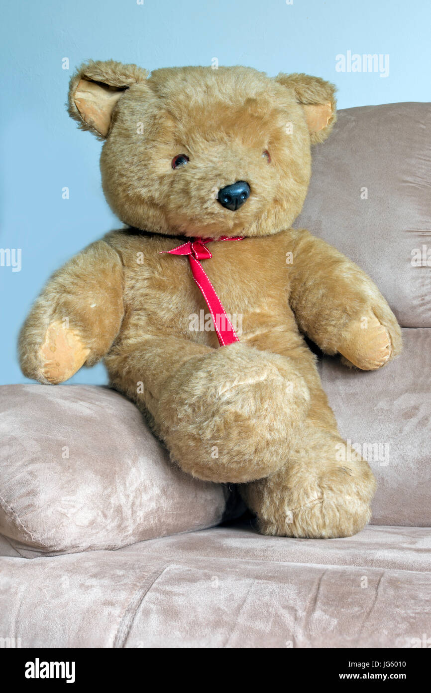 Big toy teddy bear with red ribbon round its neck Stock Photo - Alamy